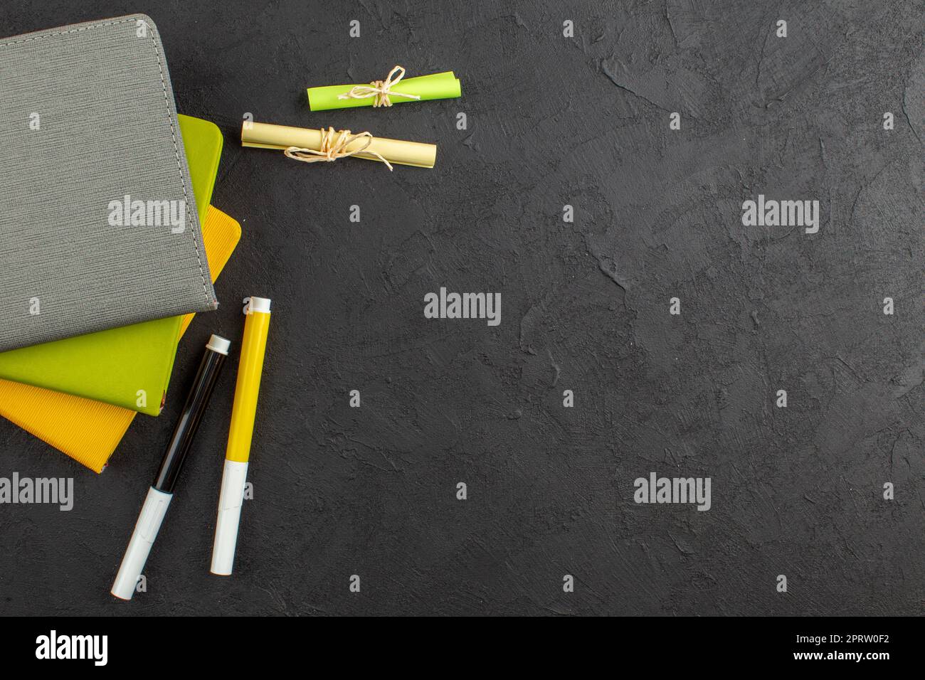 top view colorful notepads yellow and black pencils on black background ...