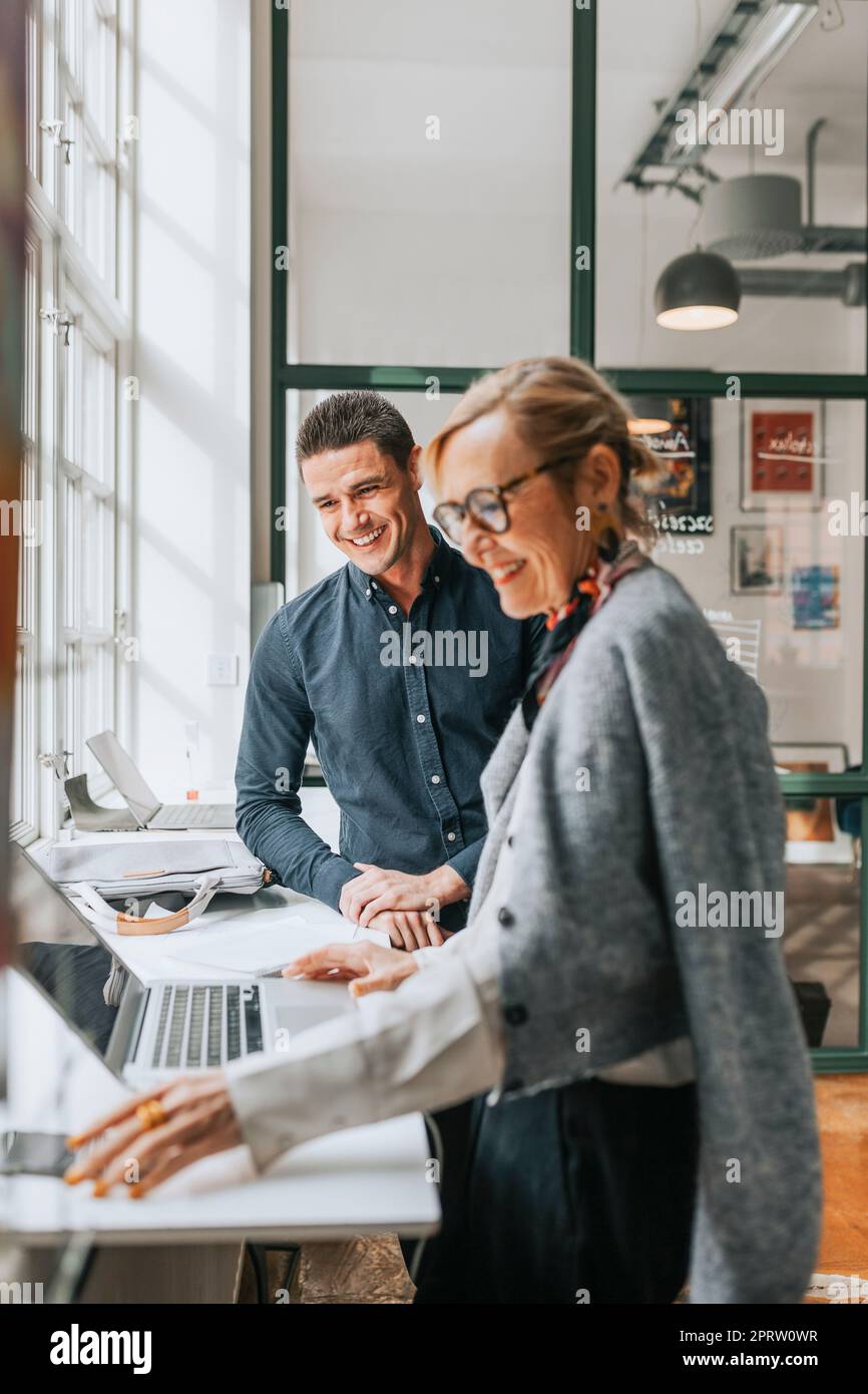 Happy male and female business people at desk in modern office Stock ...