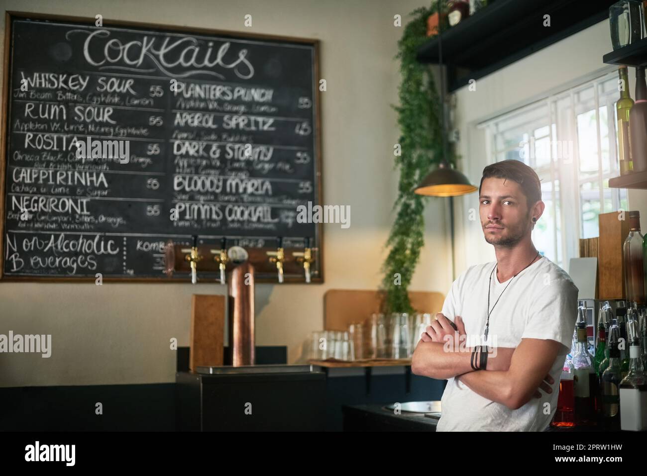 He takes mixology seriously. Portrait of a serious young bartender ...