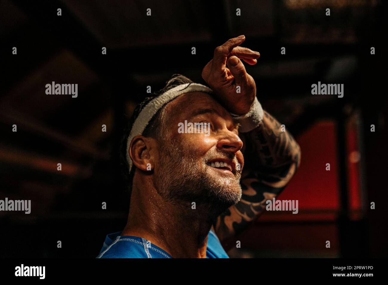 Tired male athlete wiping sweat from forehead at sports court Stock ...