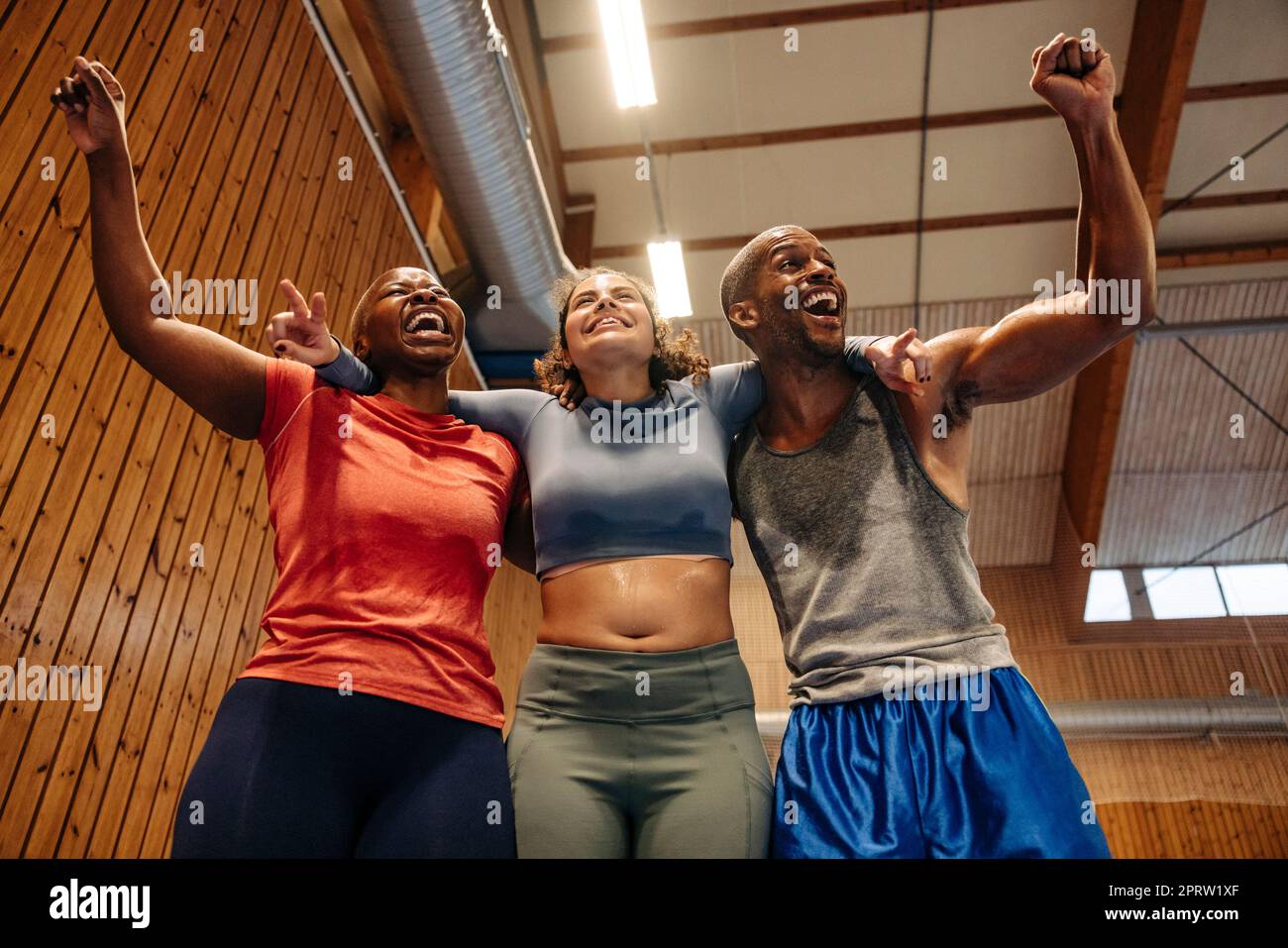 Excitement male and female athletes cheering together at sports court ...