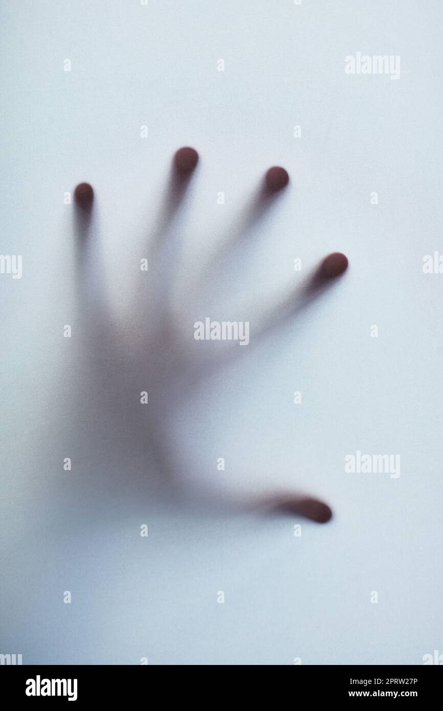 Feeling trapped. Defocussed shot of a single hand reaching out against ...