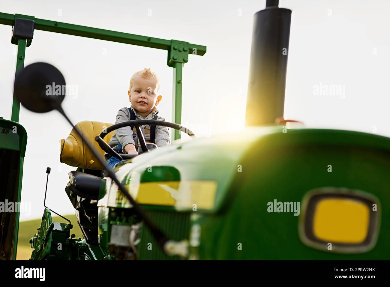 Trading modern toys for tractors. an adorable little boy riding a ...