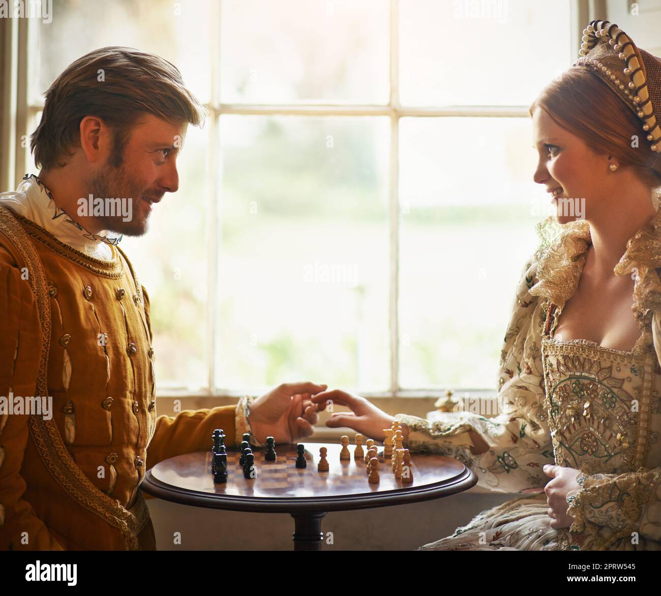 I surrender to you my lady. a an aristocratic couple playing chess ...