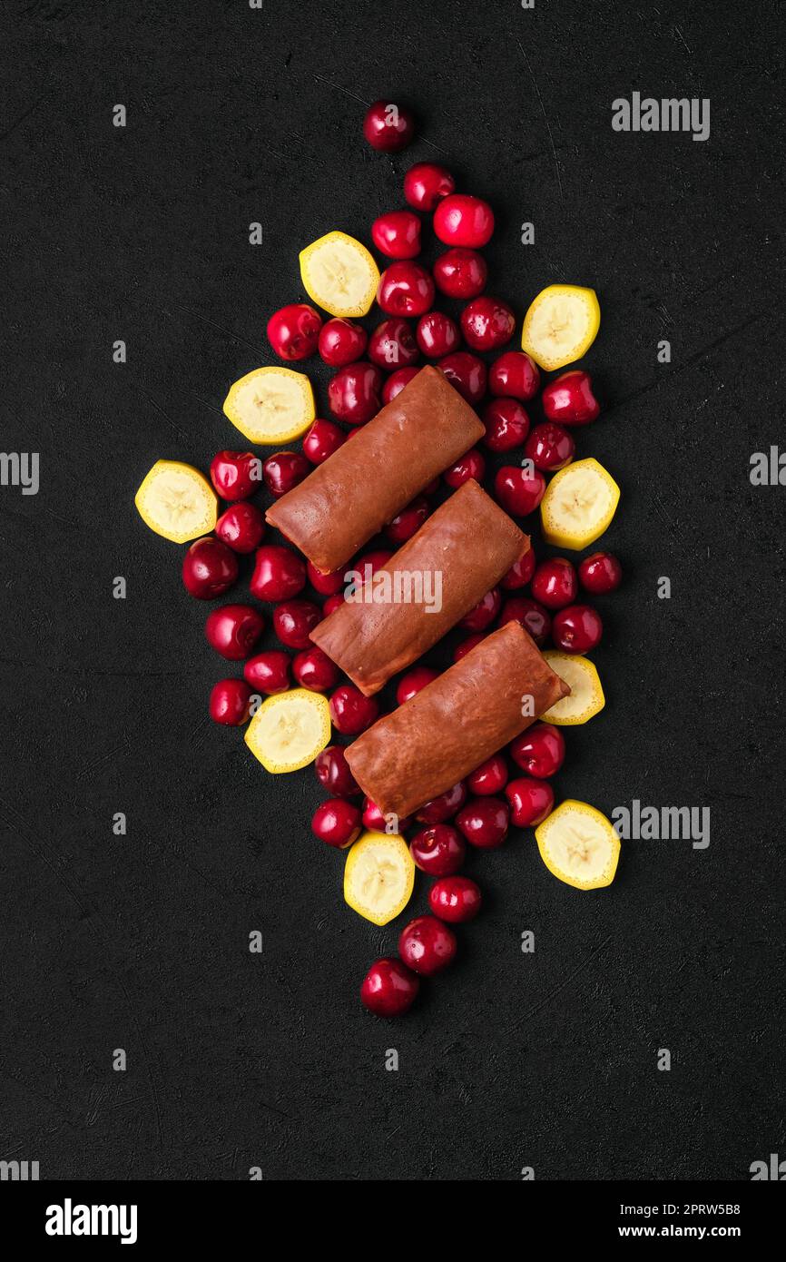 Overhead composition with thin chocolate pancakes stuffed with cottage ...