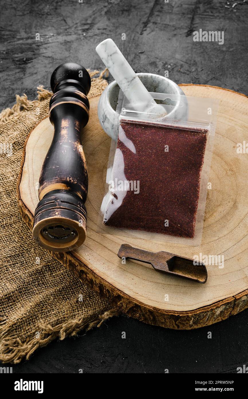 Wooden cross section with sumac in plastic package and mortar and mill ...