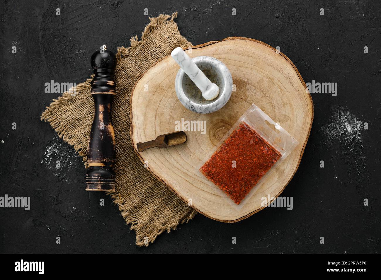 Wooden cross section with paprika in plastic package and mortar and ...