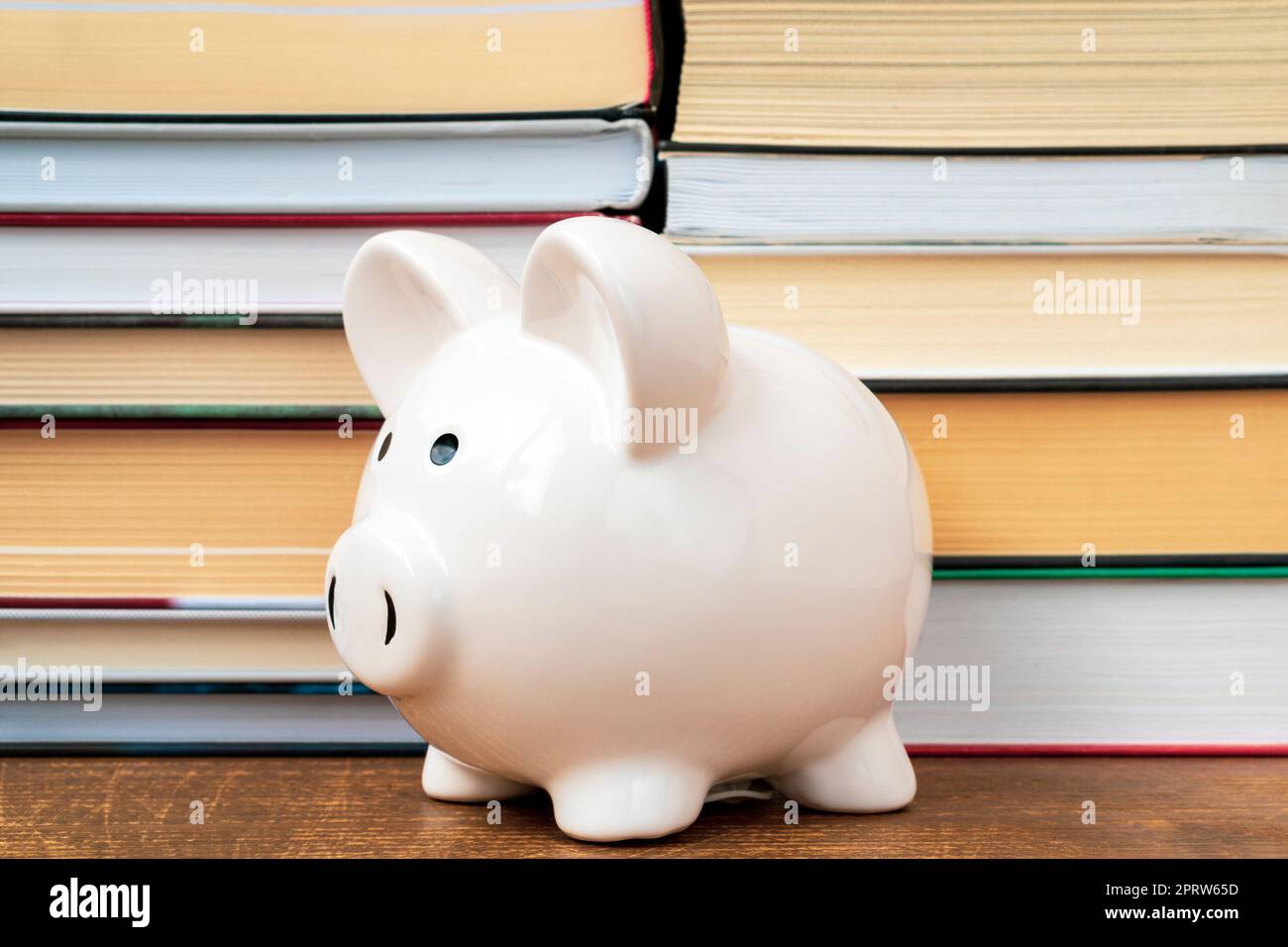 White piggy bank and stacked books on background Stock Photo - Alamy