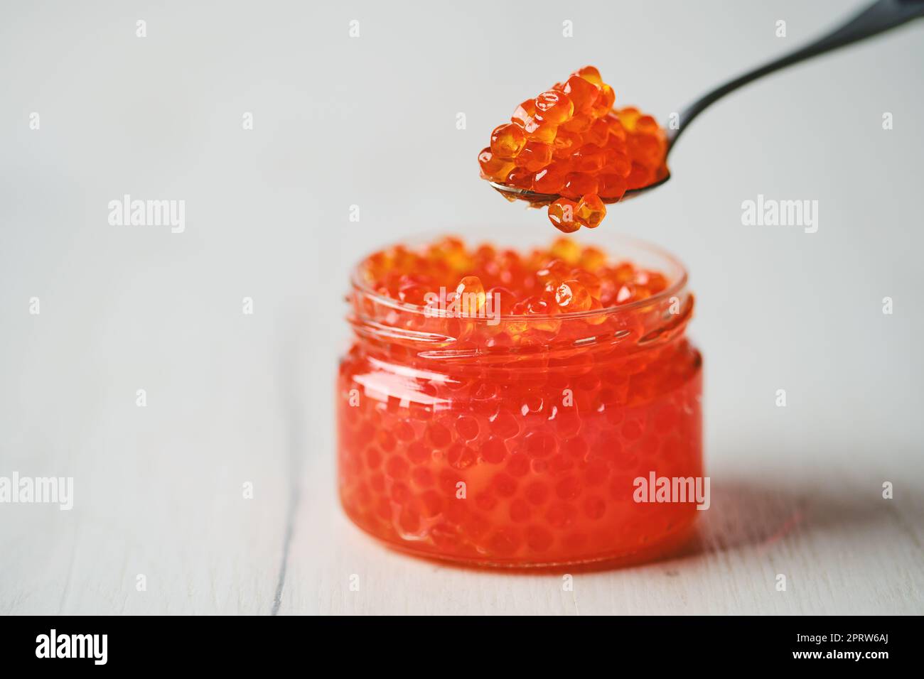Open jar with red caviar and a spoon above it Stock Photo - Alamy