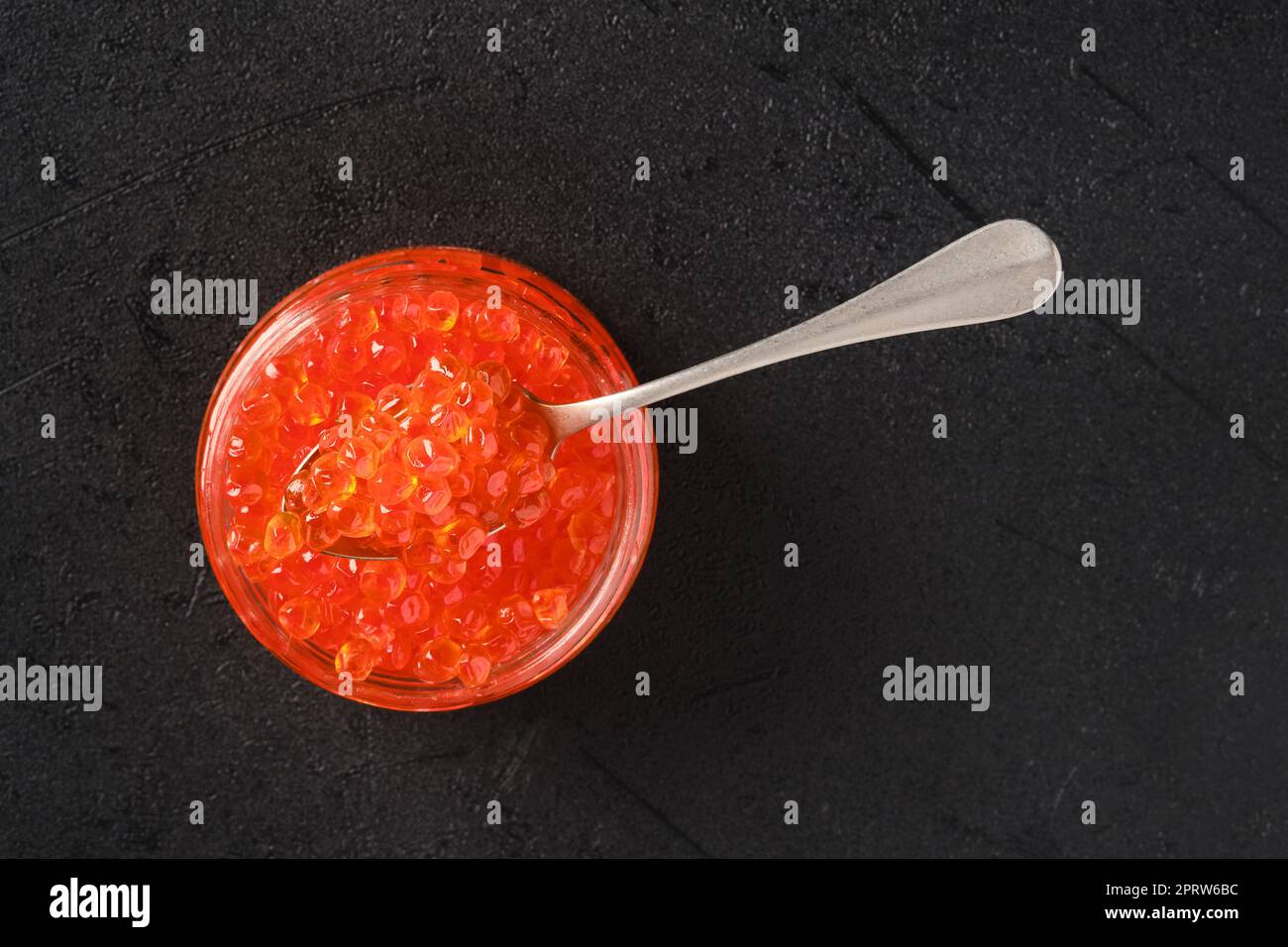 Top view of open jar with red caviar and a spoon in it Stock Photo - Alamy