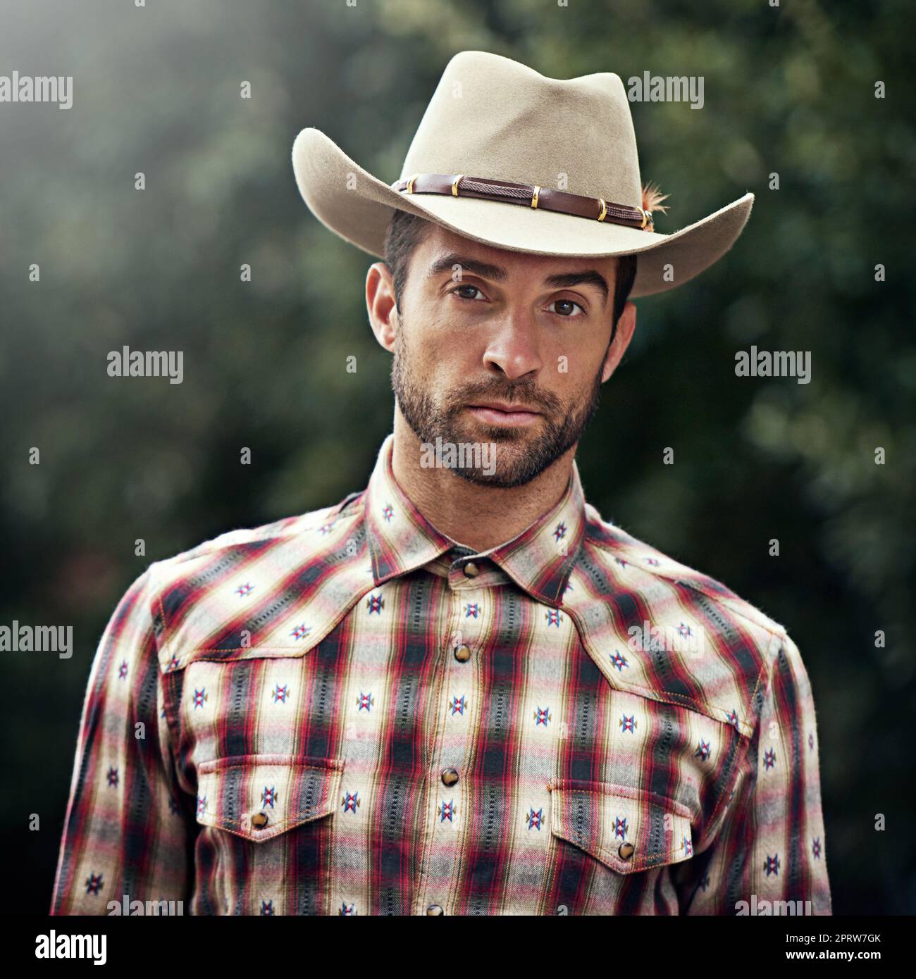 The bigger the hat, the better the cowboy. a handsome cowboy wearing a ...
