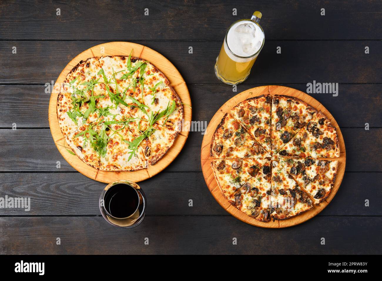 Overhead view of a table with two pizzas and glass of wine and beer ...