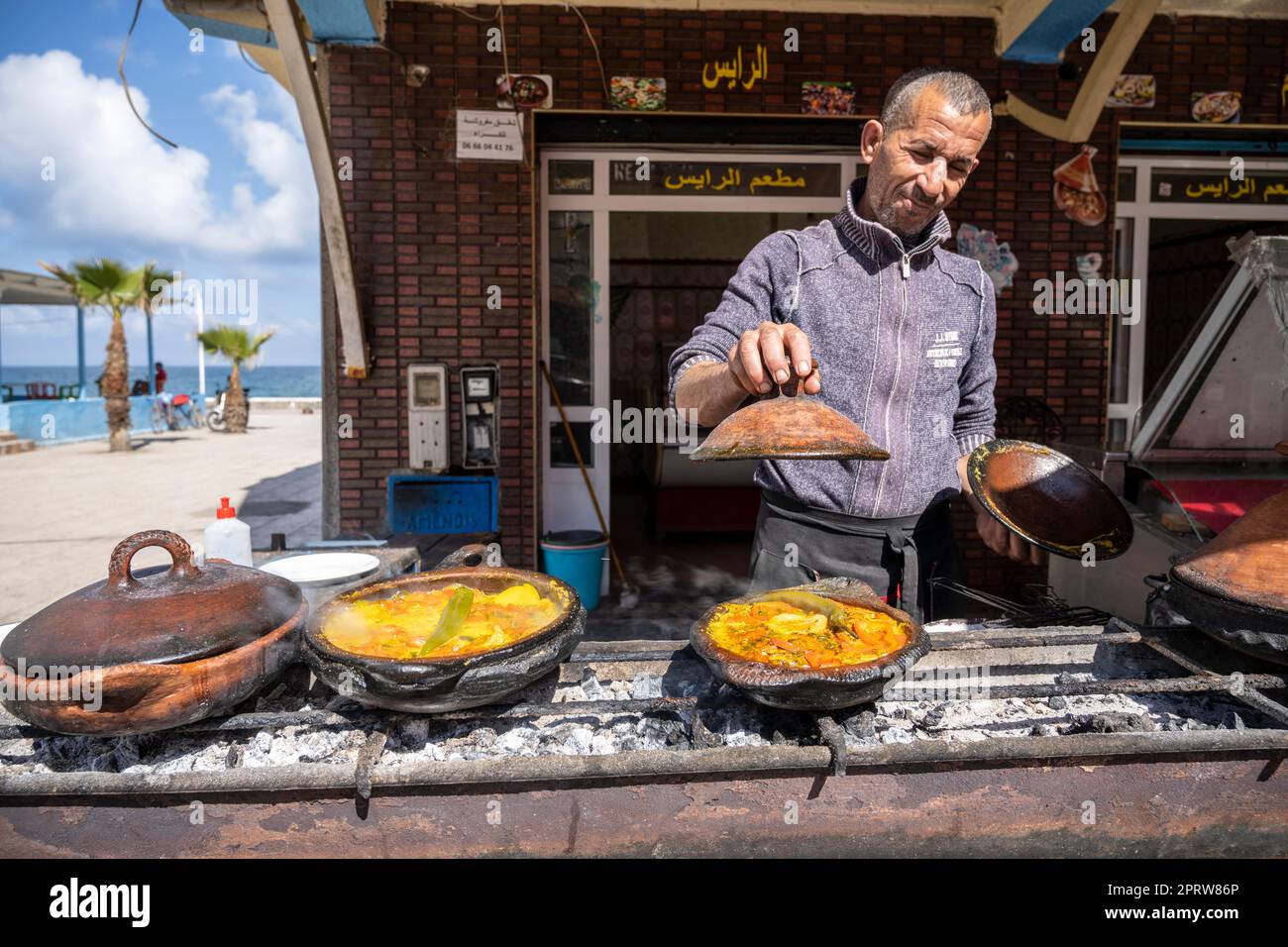 Man cooking the traditional tajine in a street restaurant in the ...