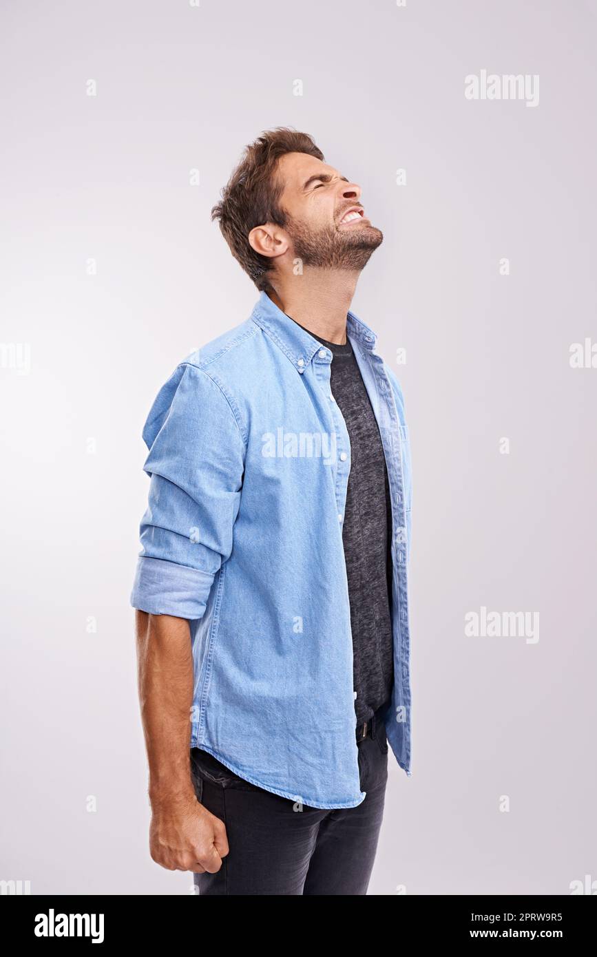 Feeling the frustration. a handsome young man looking angry against a ...