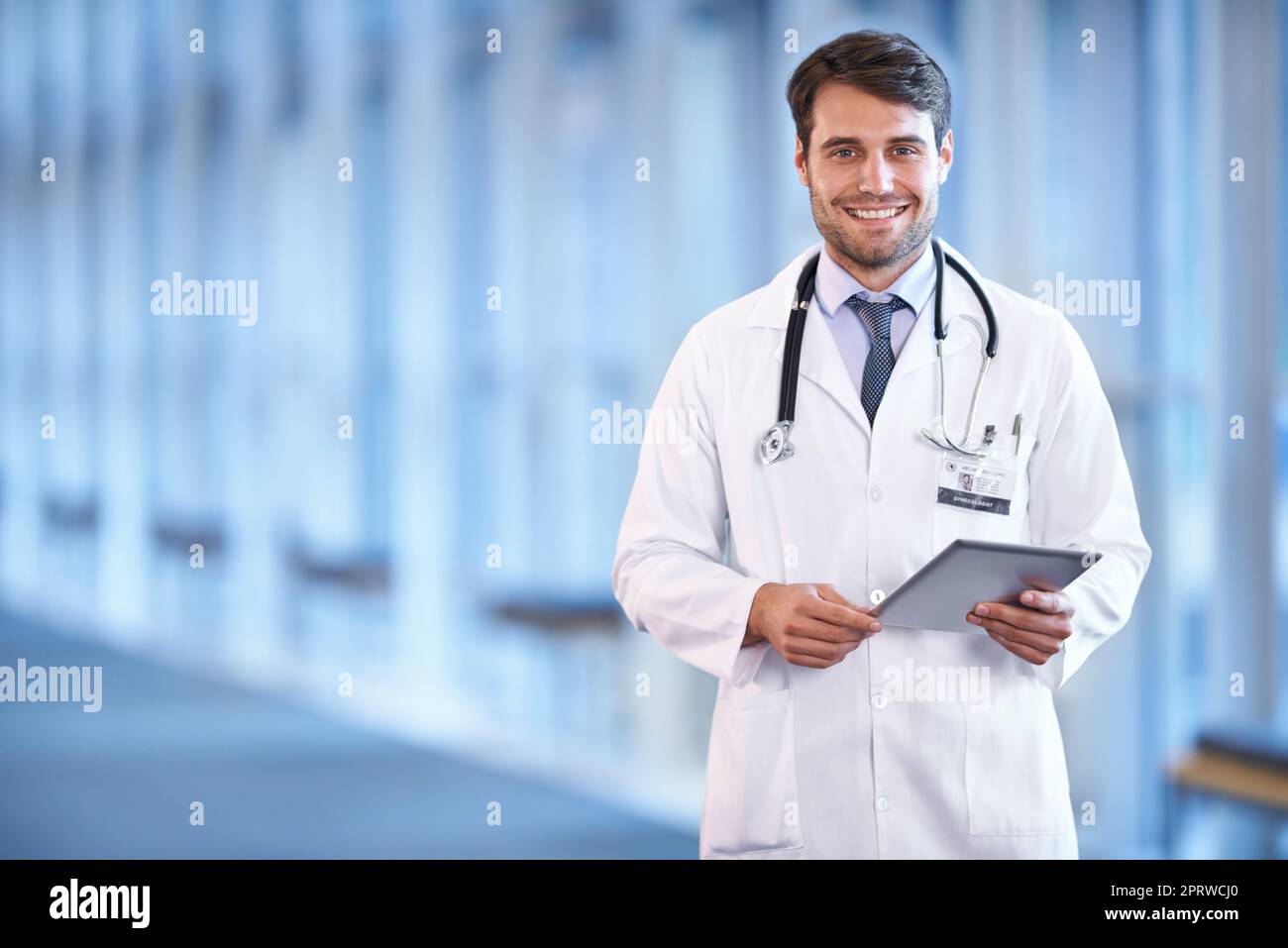 Happy to be of help. Portrait of a happy young doctor standing in a ...