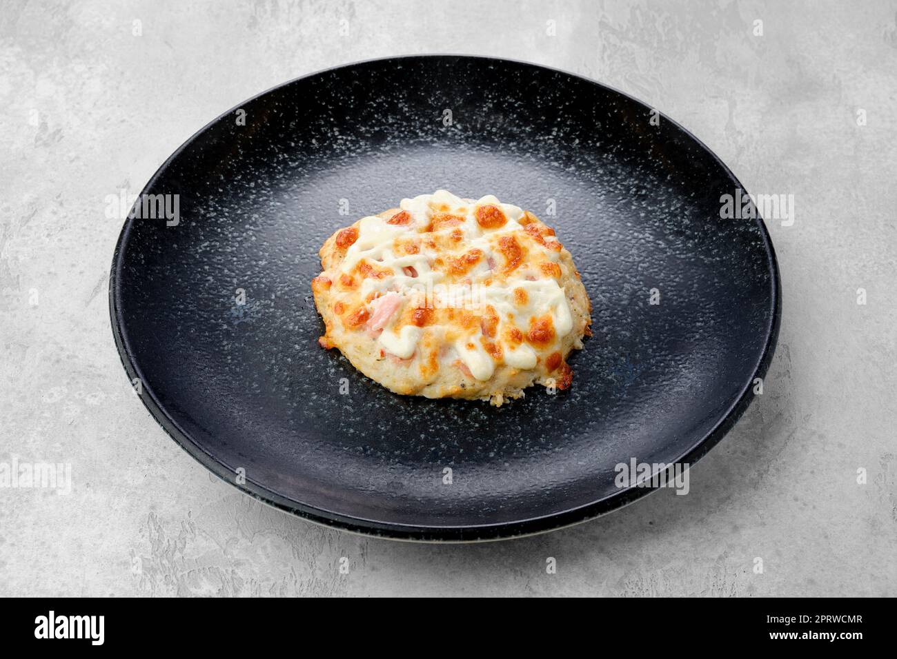 Chopped pork cutlet baked with ham and cheese Stock Photo - Alamy