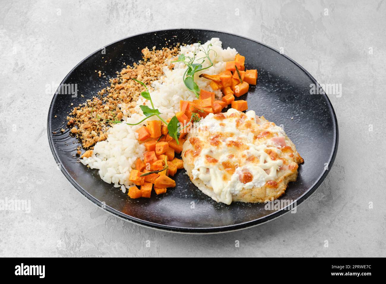 Chopped pork cutlet baked with ham and cheese served with carrot and ...