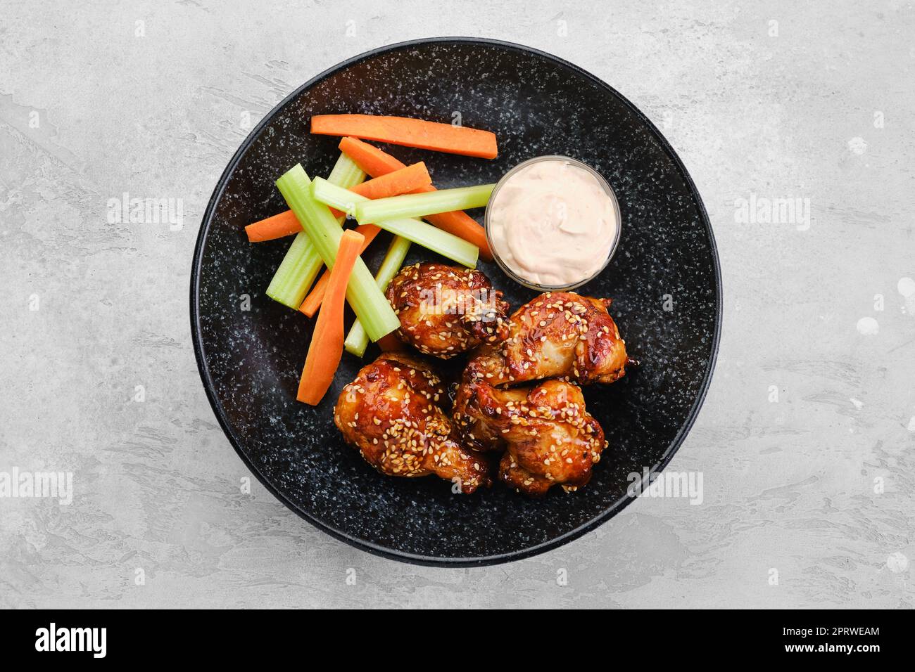 Fried chicken legs with teriyaki sauce and slices of celery and carrot ...