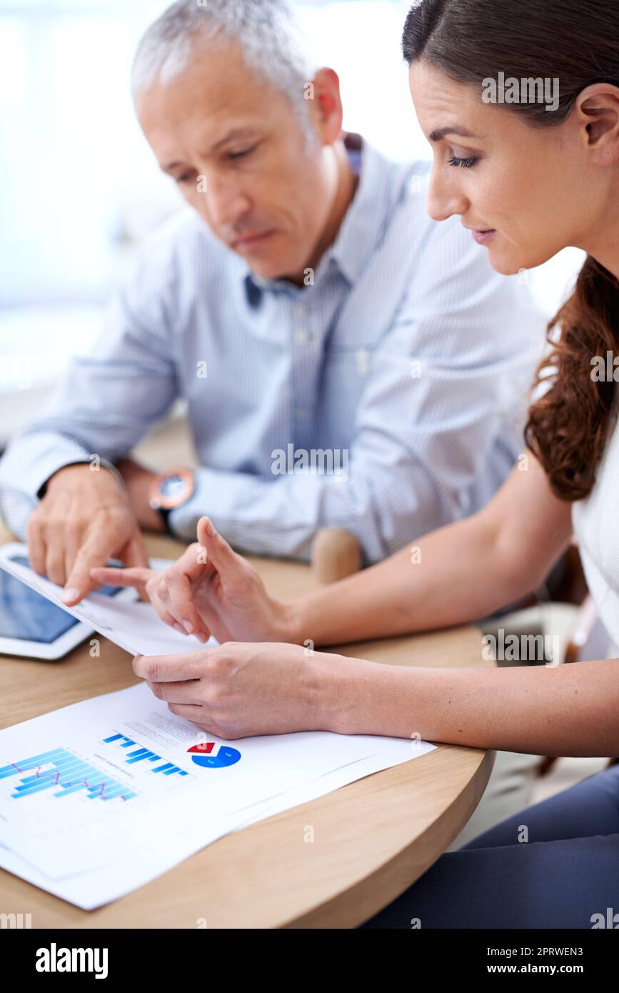 A positive outlook for the business. two colleagues reading paperwork ...