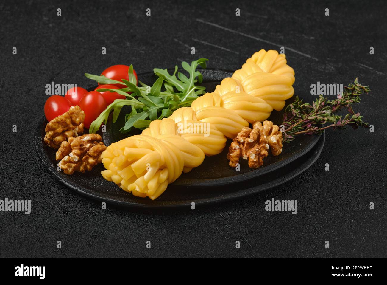 Smoked braided cheese on a plate Stock Photo - Alamy
