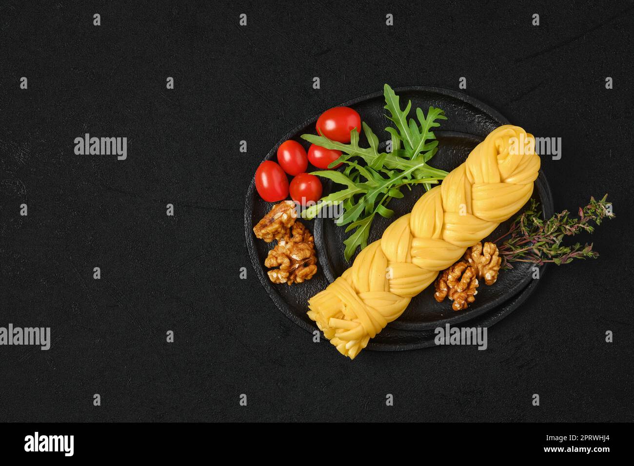 Smoked braided cheese on a plate, view from above Stock Photo - Alamy