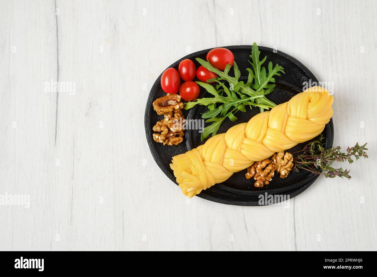 Smoked braided cheese on a plate, view from above Stock Photo - Alamy