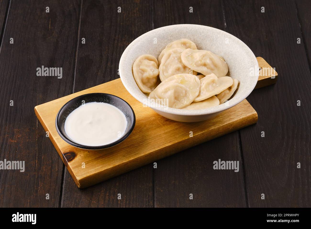 Traditional pelmeni with pork farce served with sour cream Stock Photo ...
