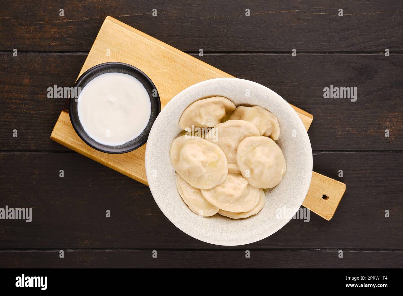 Traditional pelmeni with pork farce served with sour cream, view from ...