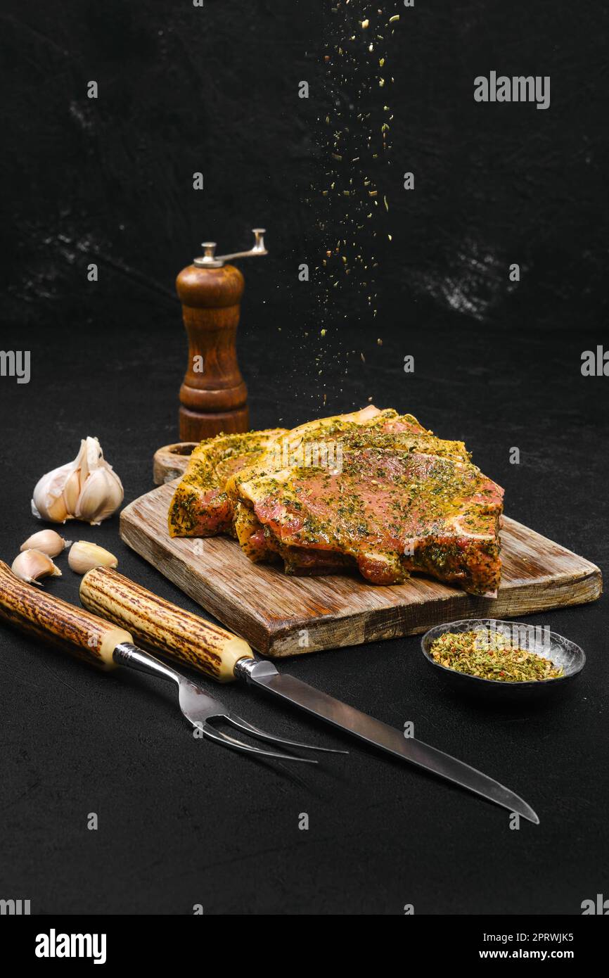 Pouring spice rub at marinated pork steak with spice Stock Photo - Alamy