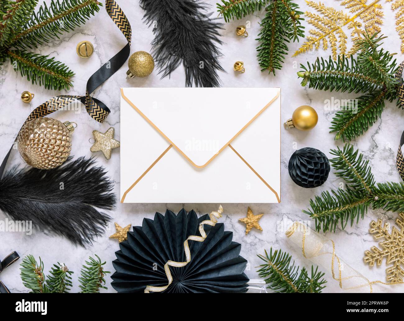 Blank envelope between black and golden Christmas decorations and fir ...