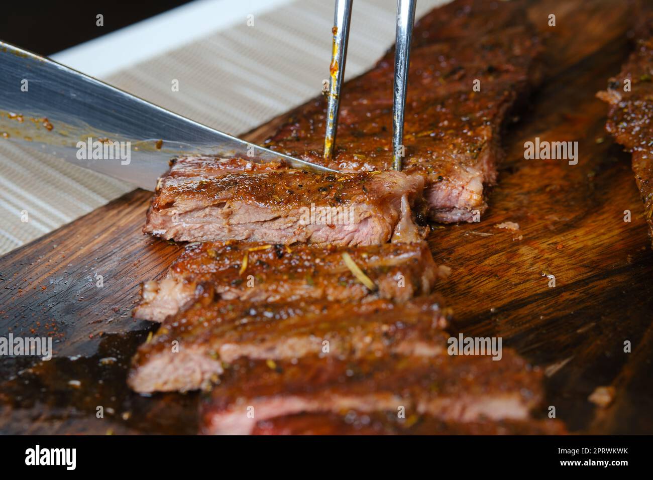 Cutting juicy top blade steak on wooden cutting board Stock Photo - Alamy