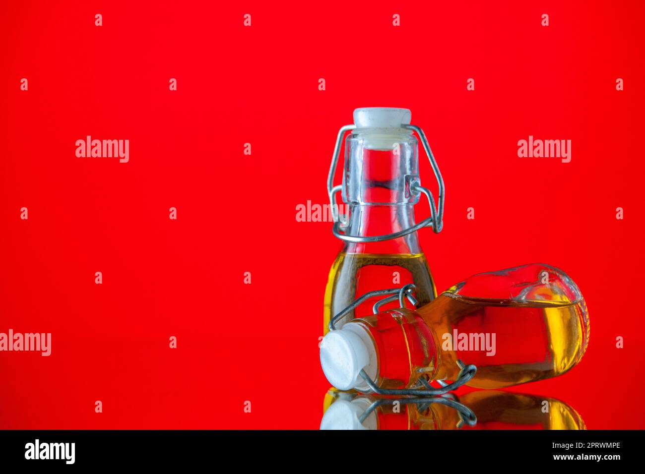 front view two oil bottles on red background free place Stock Photo - Alamy