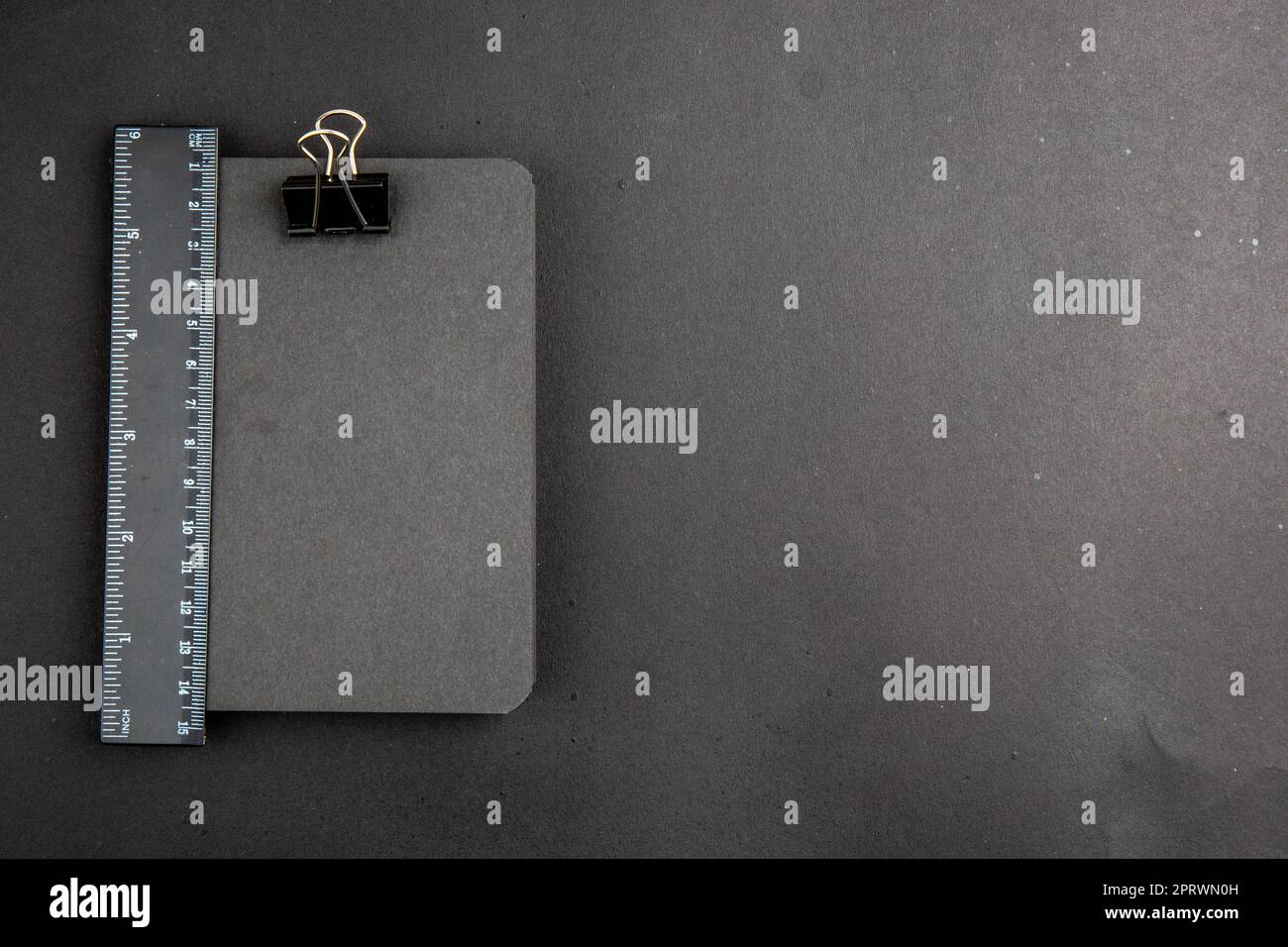 top view black ruler binder clip on notebook on dark background with ...