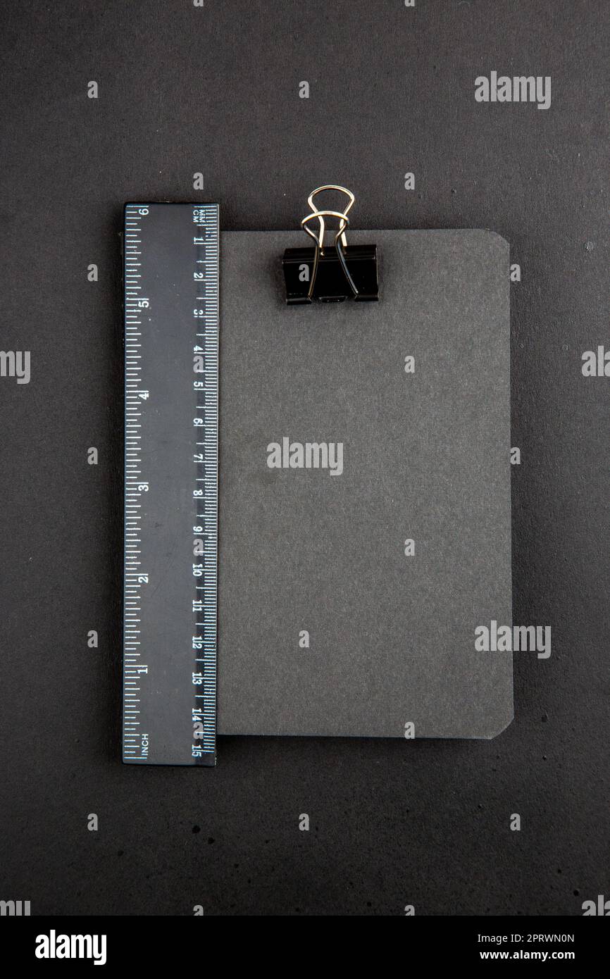 top view black ruler binder clip on notebook on dark background Stock ...
