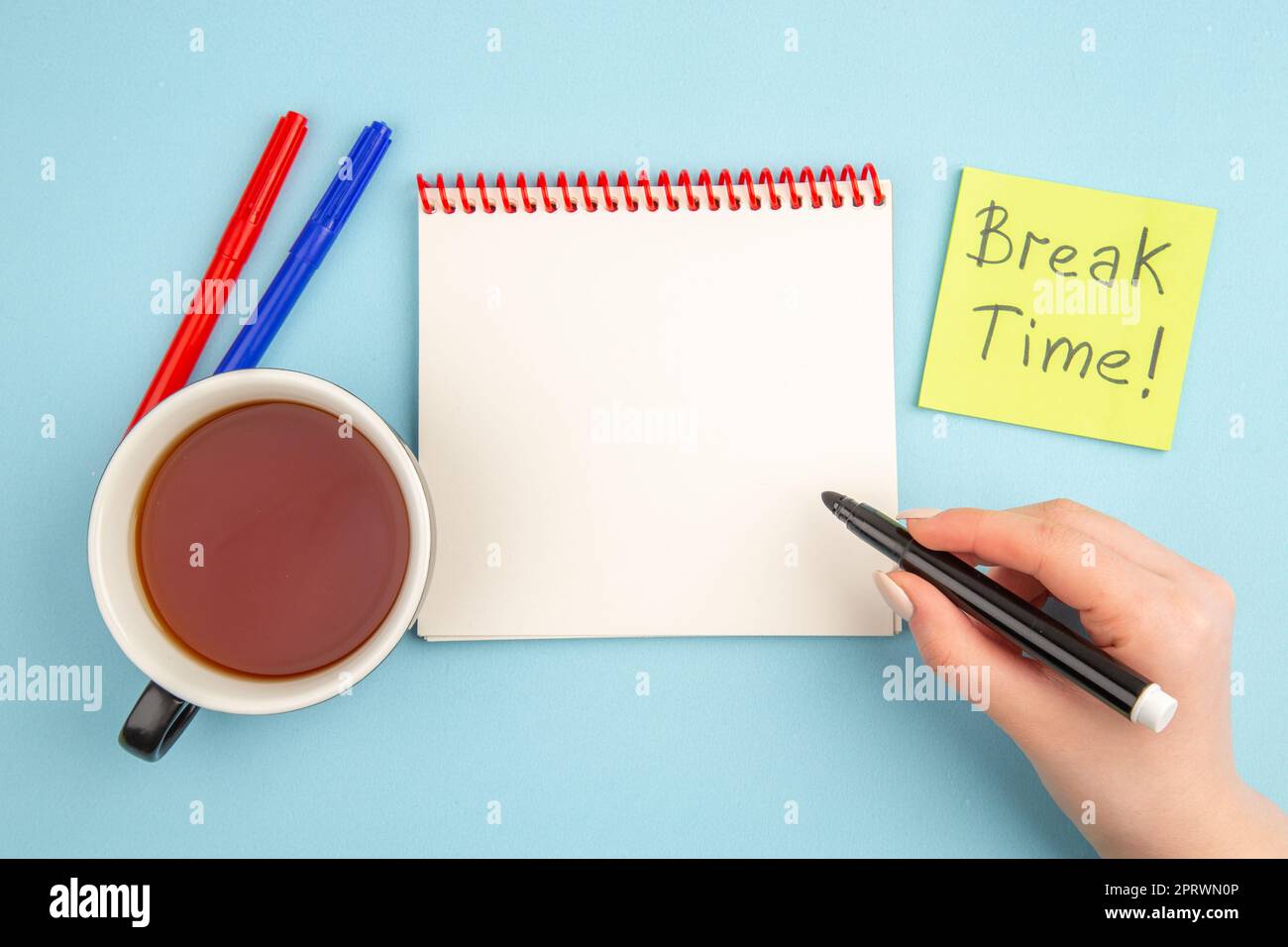 top view break time written on yellow sticky note notebook cup of tea ...