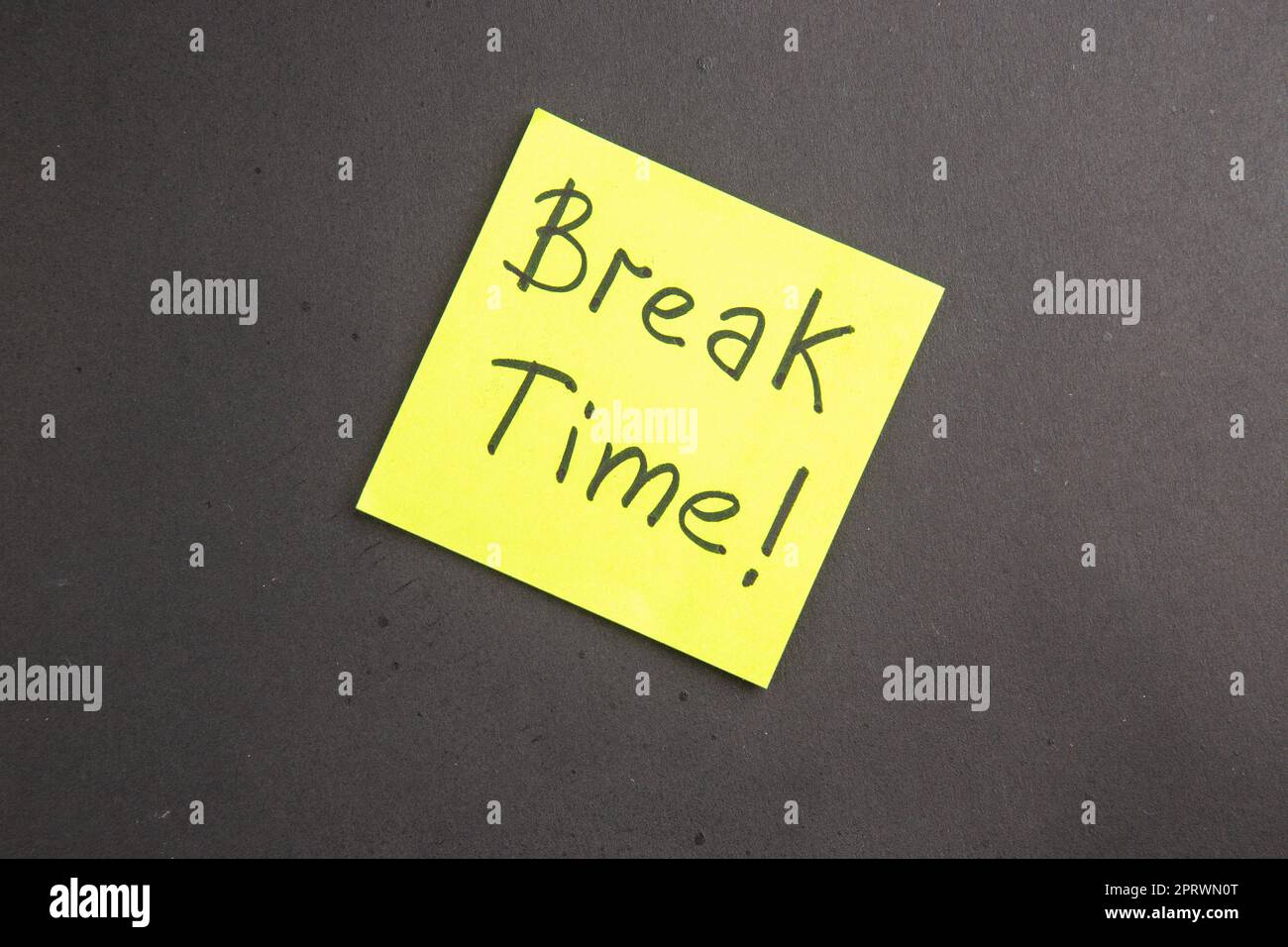 top view break time written on yellow sticky note on dark background ...