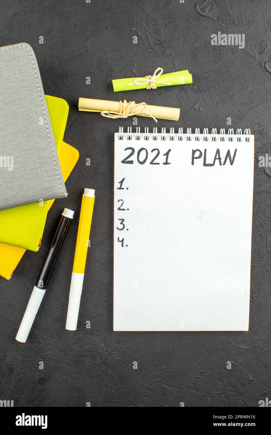 top view colorful notepads yellow and black markers plan written on ...