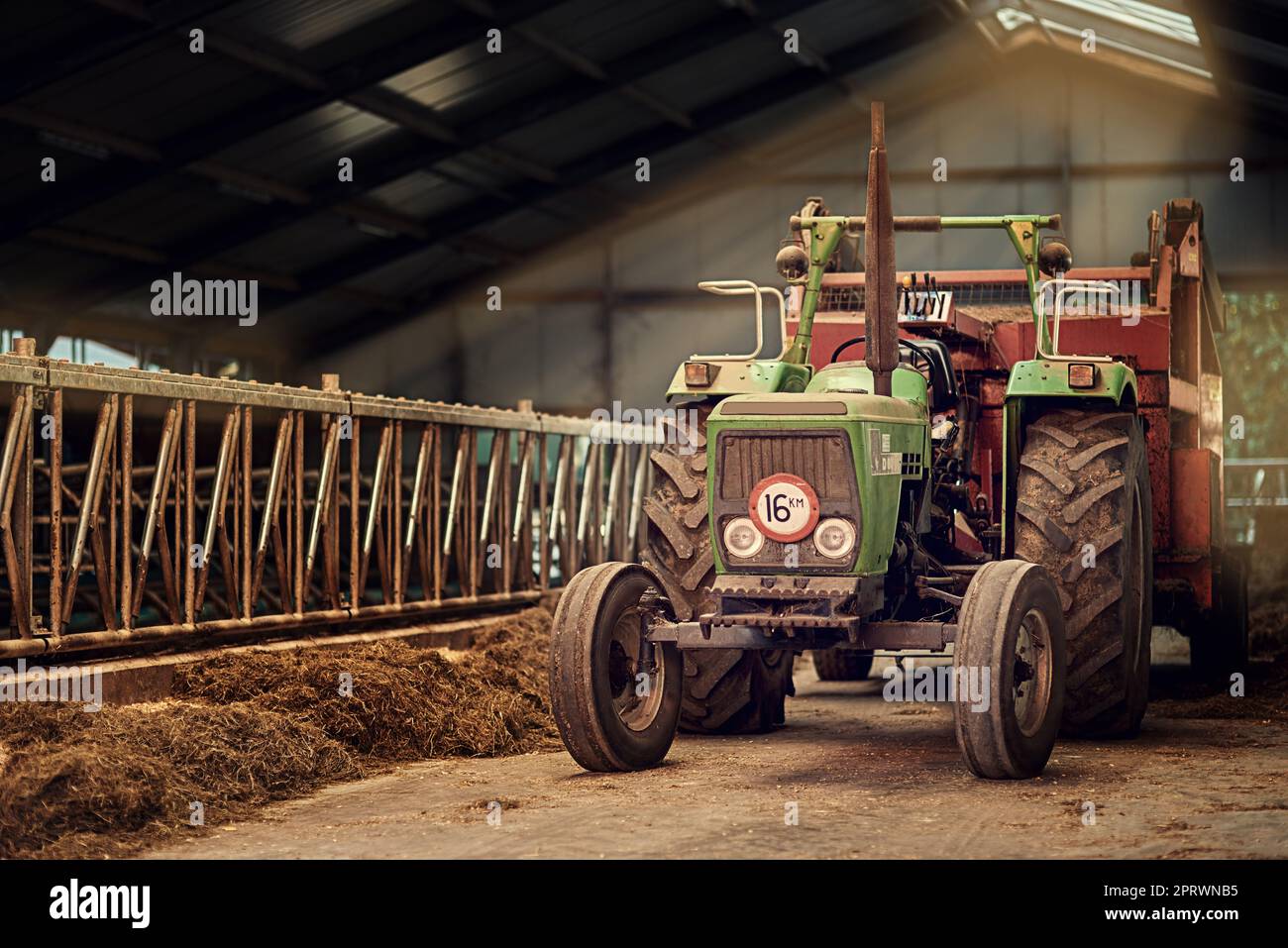 Ready to rumble. a rusty old tractor standing in an empty barn Stock ...