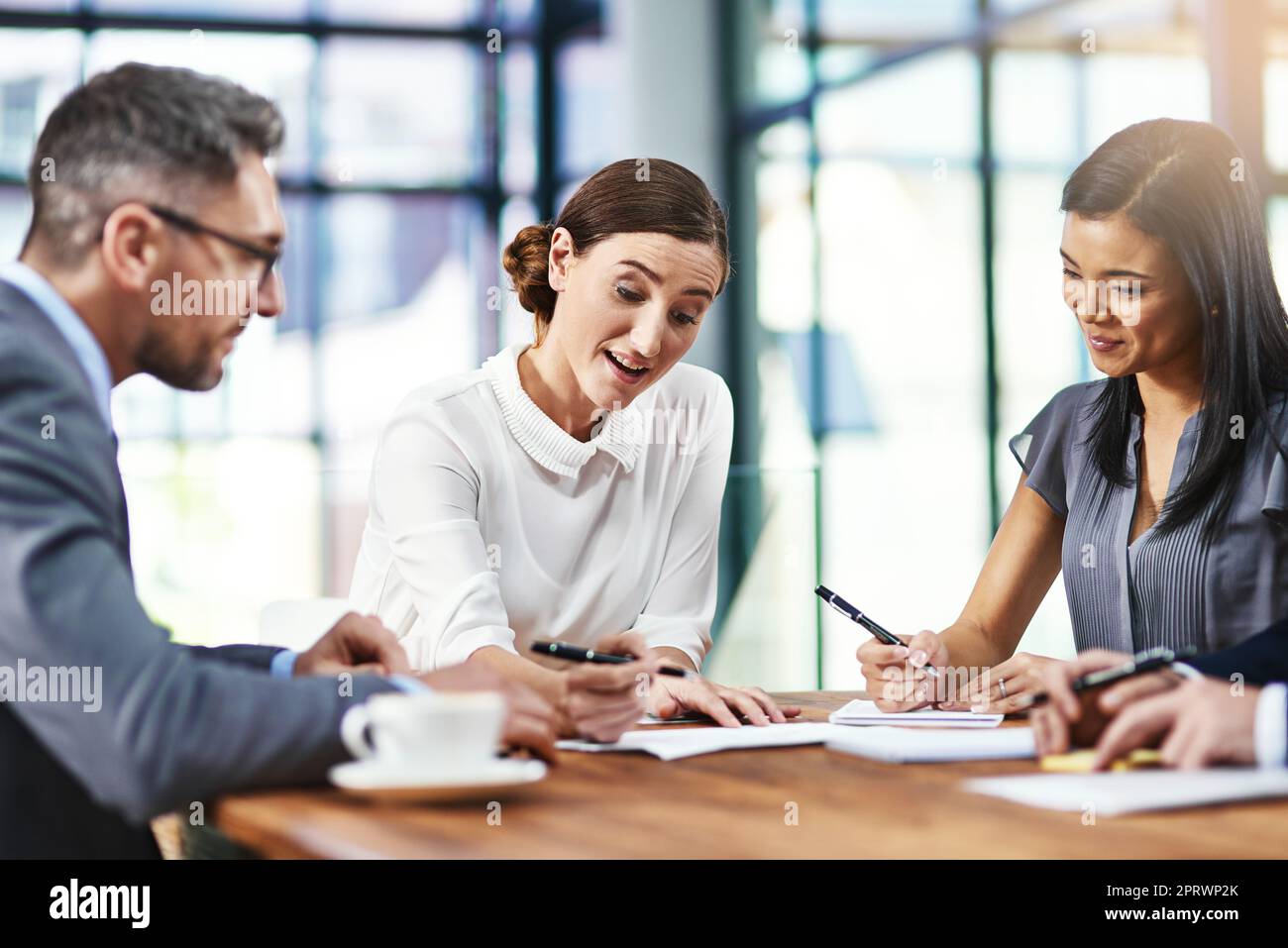 Getting down to business in the office. a group of colleagues working ...