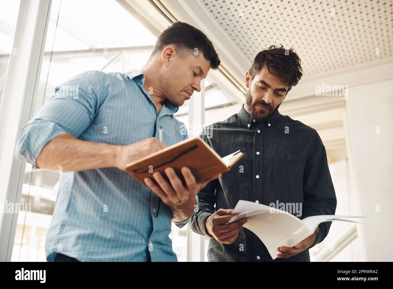 Two business people comparing notes hi-res stock photography and images ...