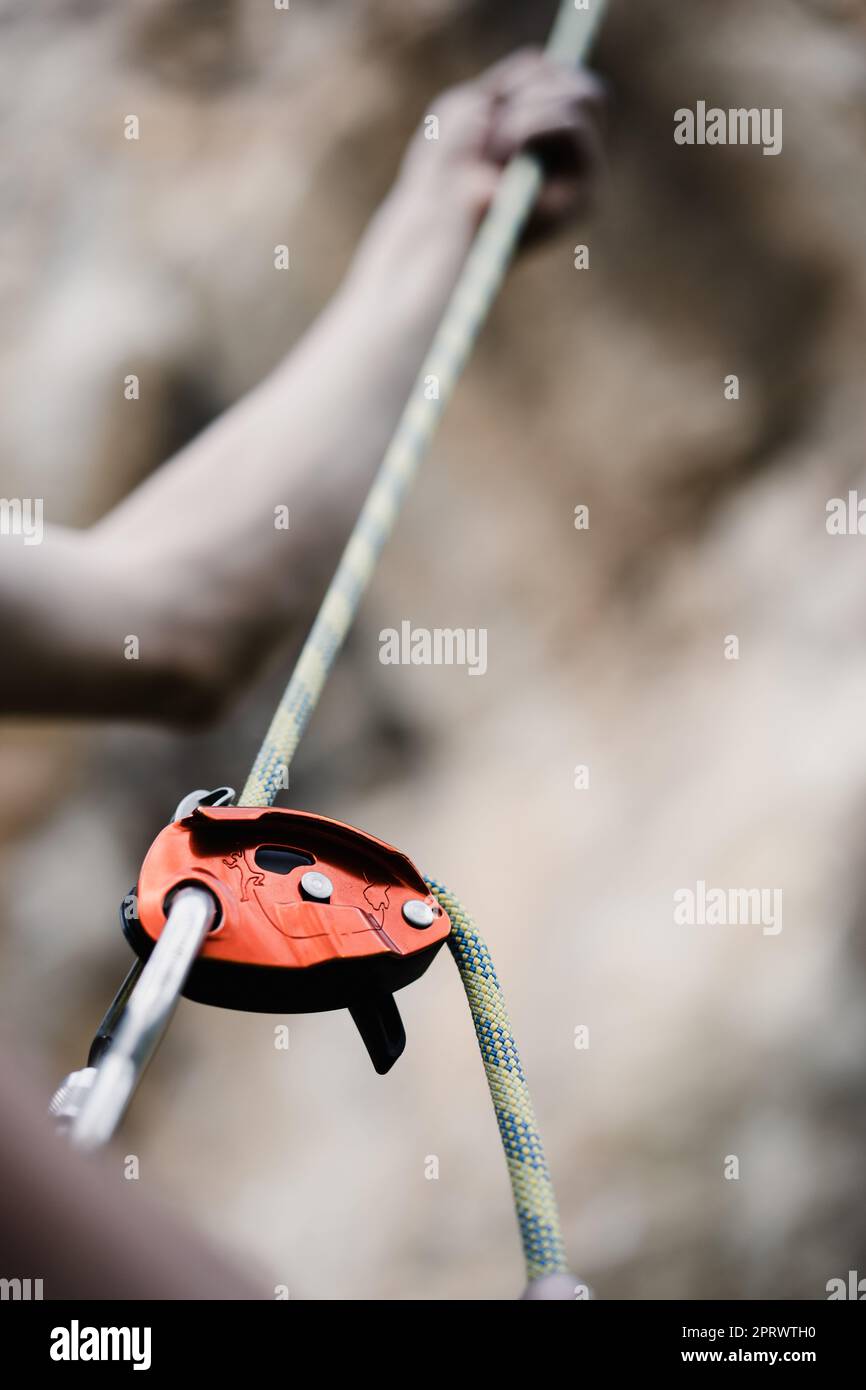Man's hands operating a rock climbing belaying device Stock Photo - Alamy