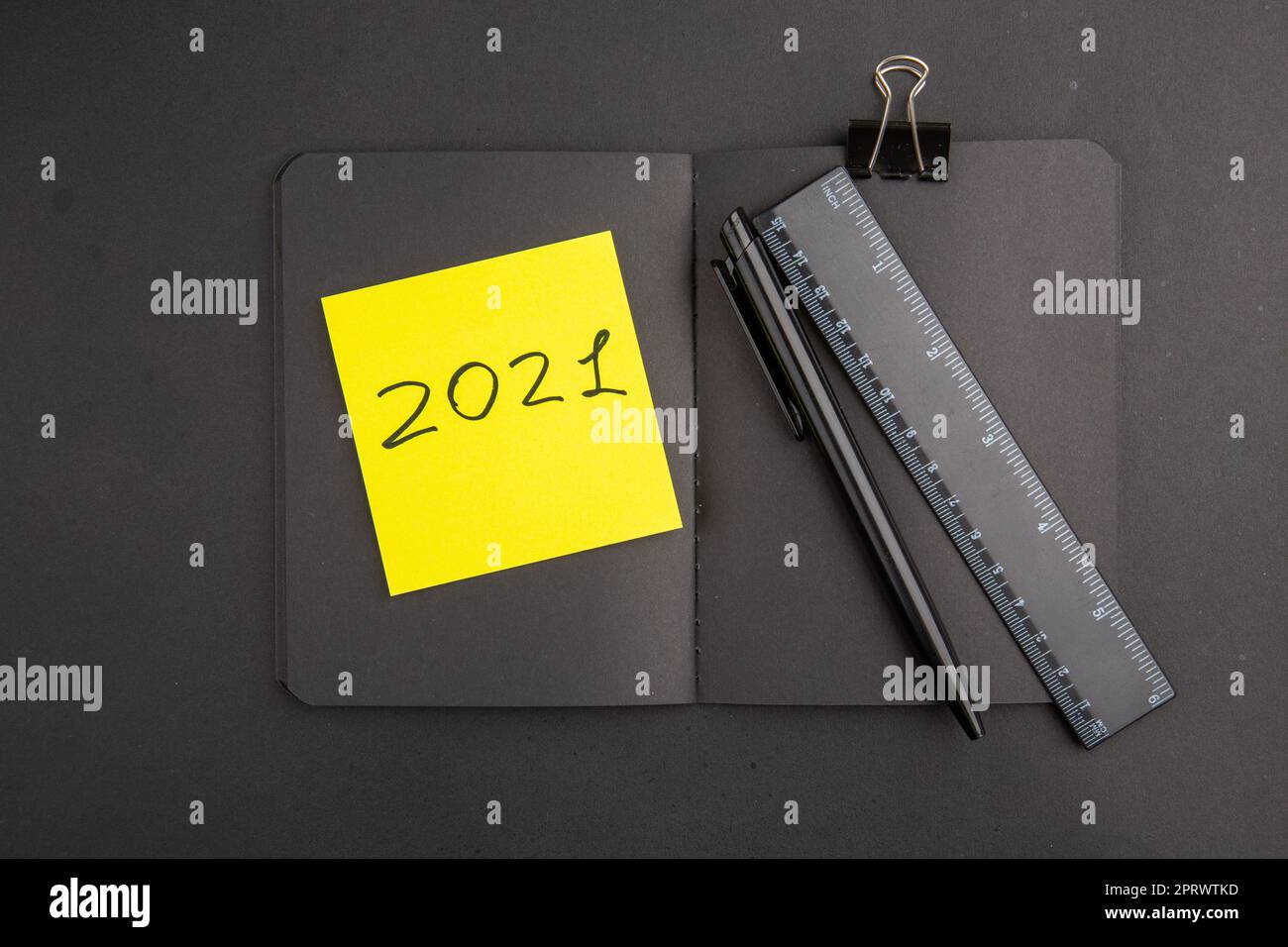 top view black notepad written on note paper ruler pen binder clip on ...