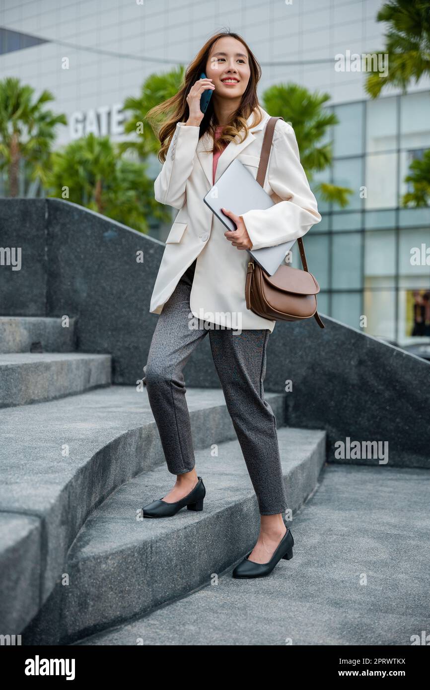 Business woman hold laptop computer talking mobile phone she hurry up ...