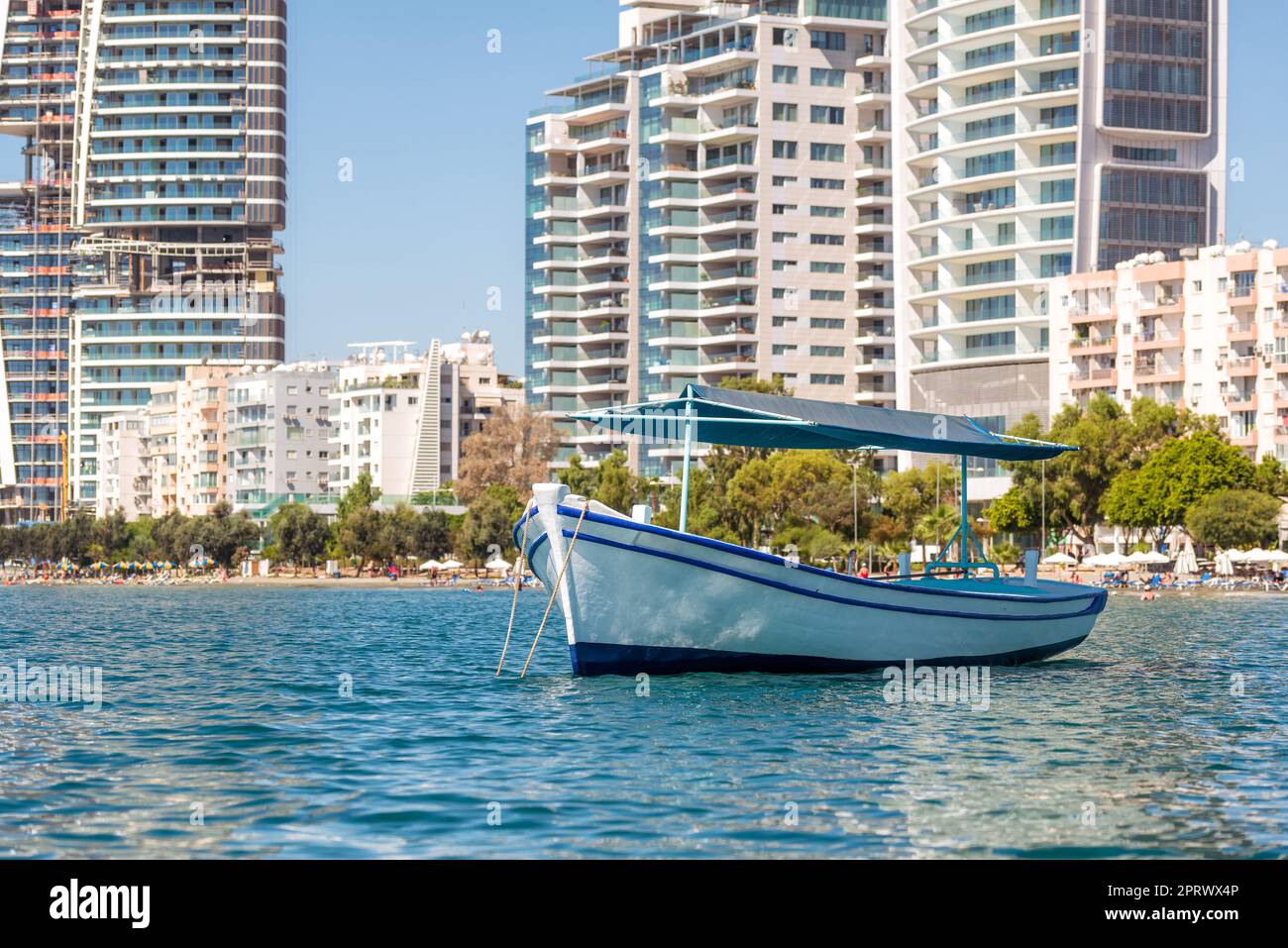 Old tiny boat and Limassol cityscape. Cyprus Stock Photo - Alamy