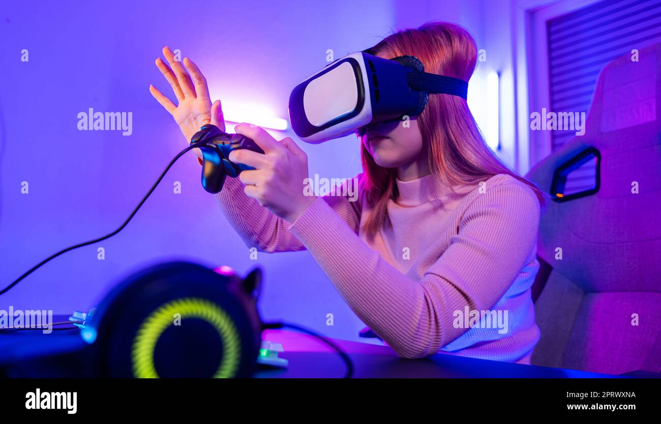 Gamer in VR headset glasses exploring metaverse plays online video game ...