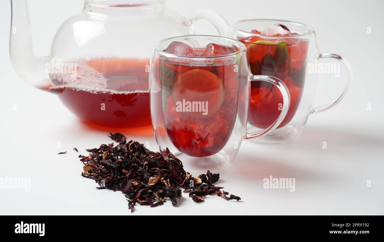 Hibiscus cold tea drink with ice cubes and lemon in glass Stock Photo ...