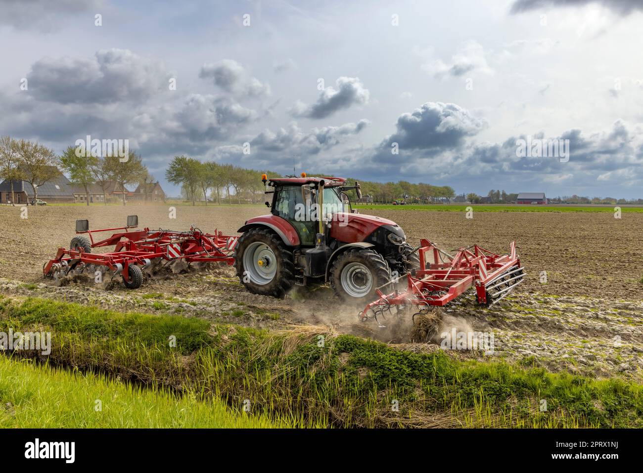 Tractor during spring work on the field Stock Photo - Alamy