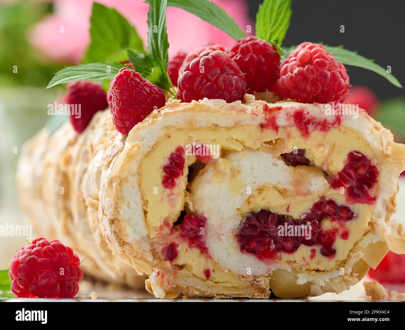 Baked meringue roll with cream and fresh red raspberry Stock Photo - Alamy