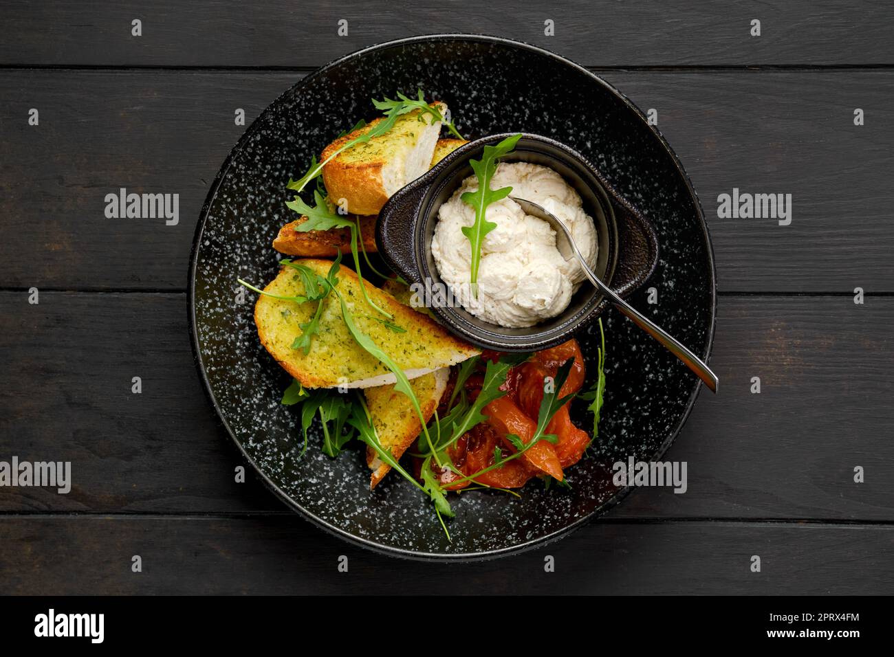 Top view of toasted garlic bread with sour curd and braised tomato ...