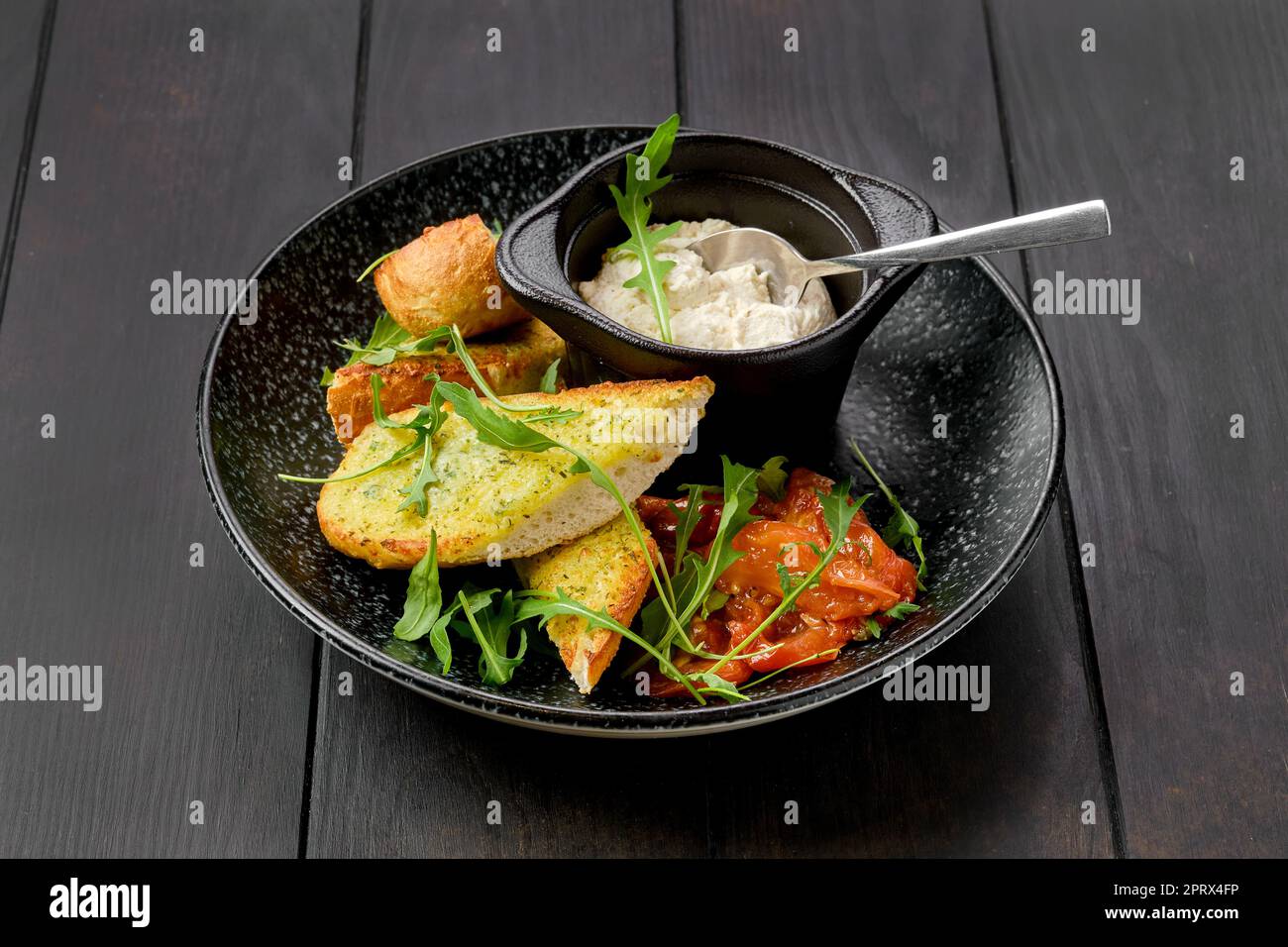 Toasted garlic bread with sour curd and braised tomato Stock Photo - Alamy